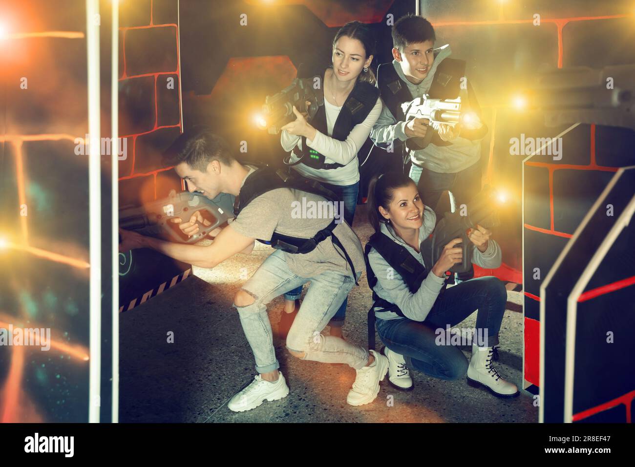 Group of young people playing laser tag game with laser guns Stock ...