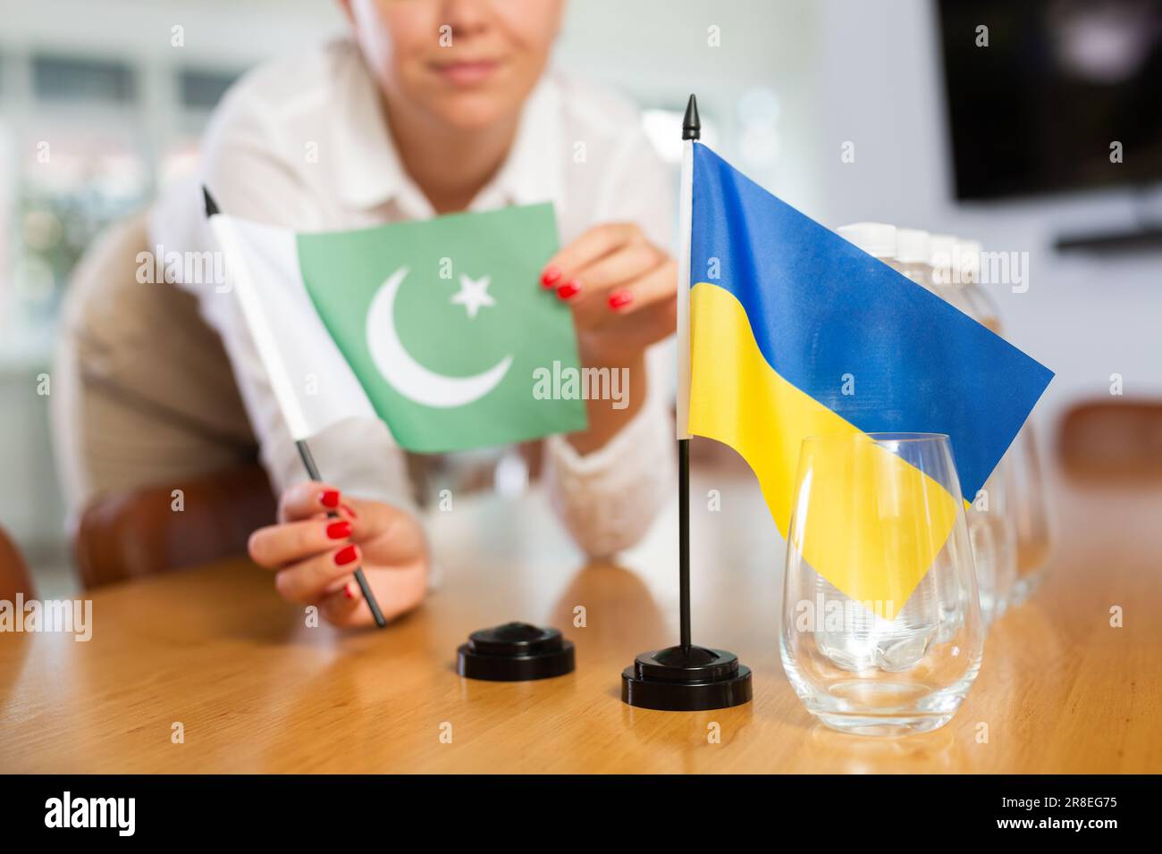 Unrecognizable girl sets midget flags of Ukraine and Pakistan before ...