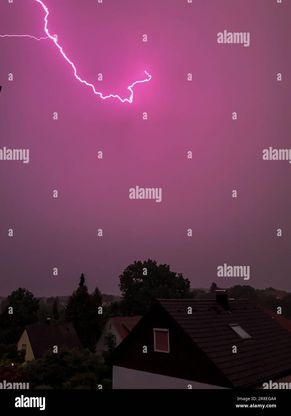 An intense pink lightning bolt illuminated the night sky Stock Photo ...