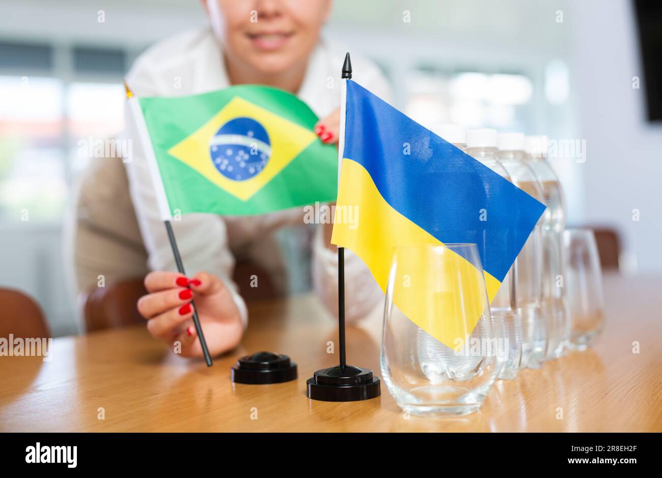 Unrecognizable girl sets midget flags of Ukraine and Brazil before ...