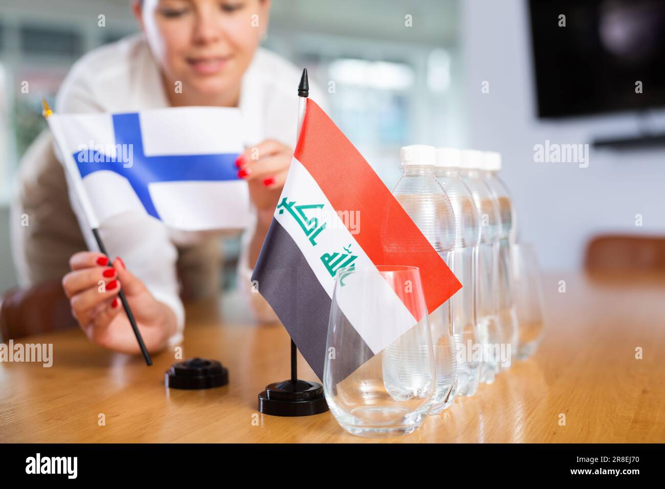Unrecognizable girl sets midget flags of Iraq and Finland before ...