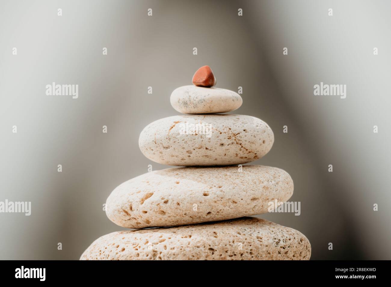 balanced rock pyramid stands tall on sea pebble beach. Selective focus ...