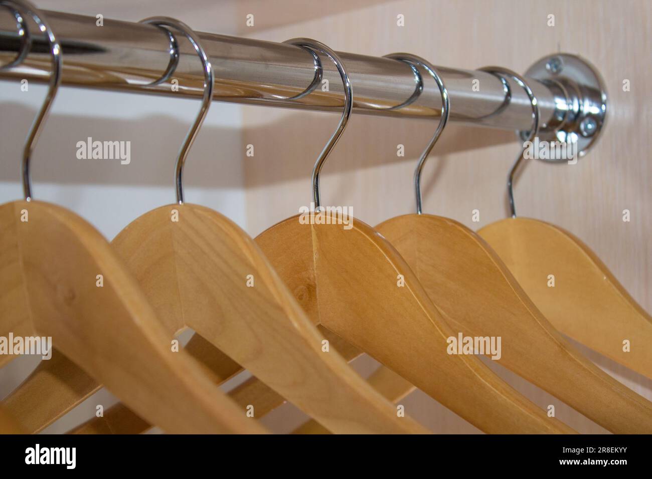 Many wooden hangers on a rod, empty wardrobe Stock Photo - Alamy