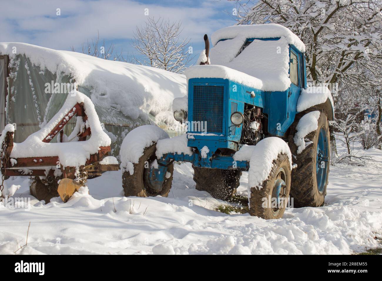 The old tractor is in the snow covered in a farm Stock Photo - Alamy