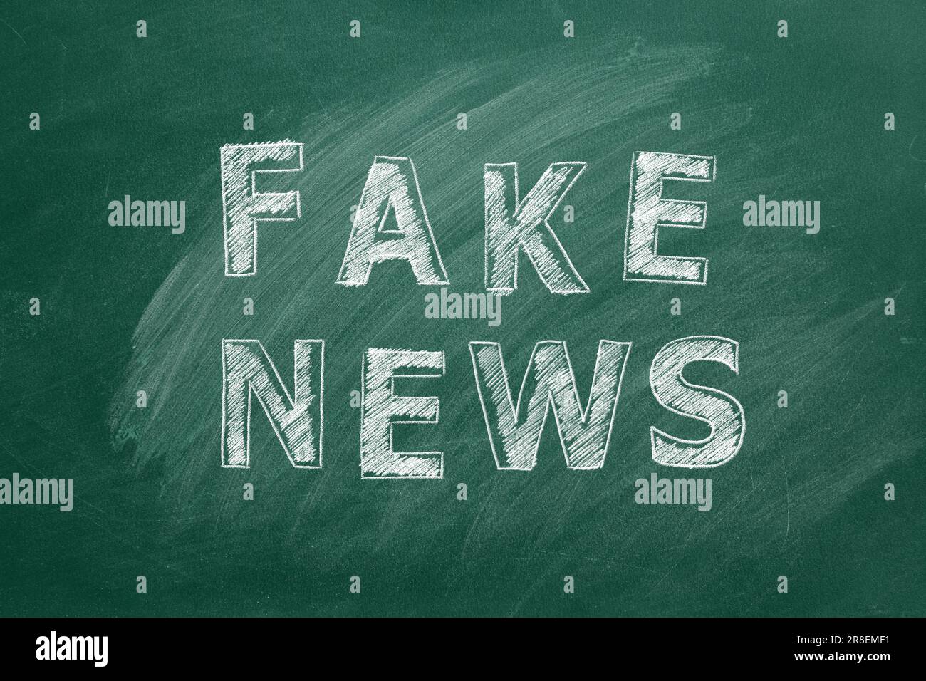 The word FAKE NEWS written in chalk on a green chalkboard. Information ...