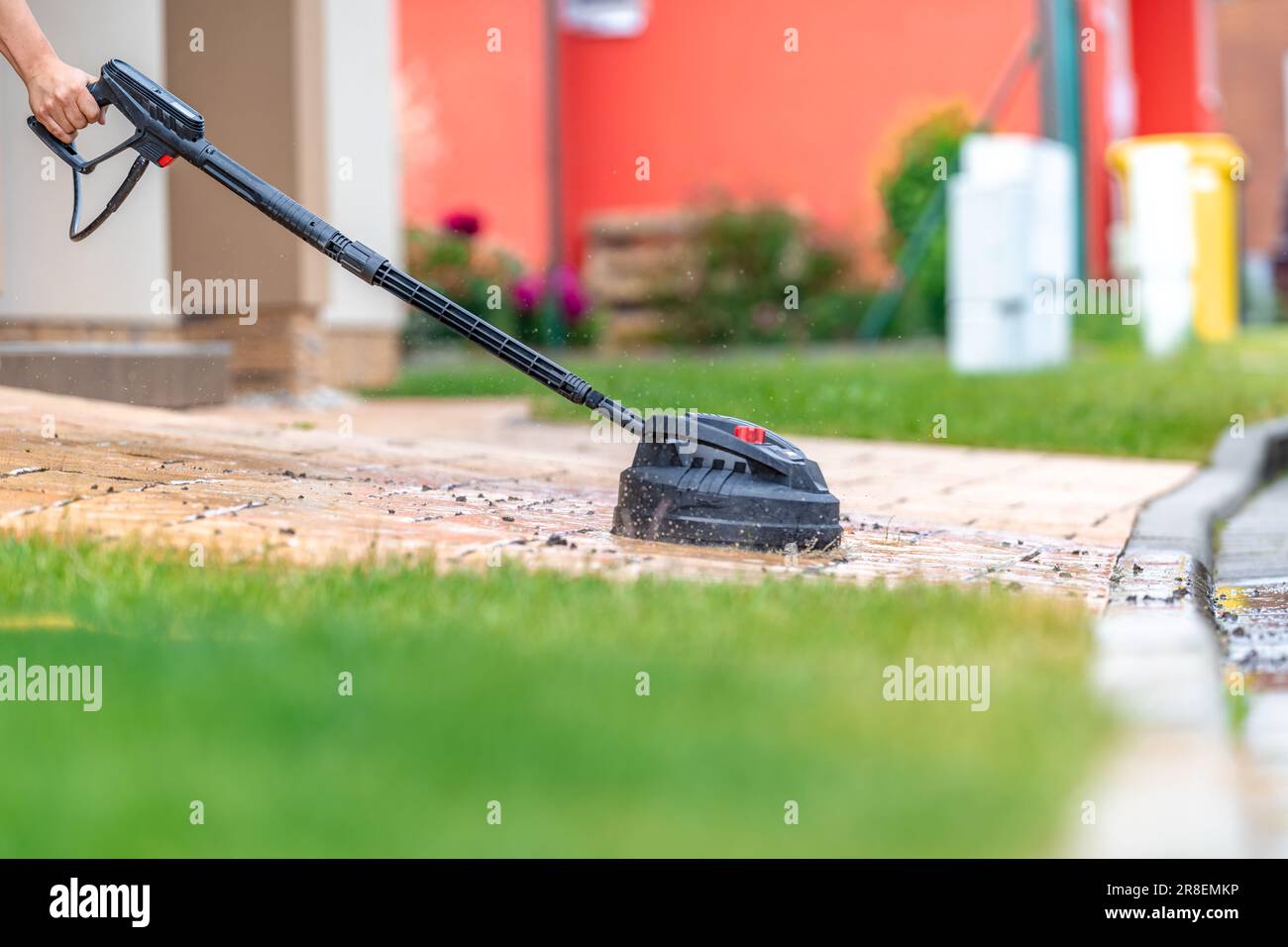 modern machine cleaning concrete pavement in front of the house with a ...