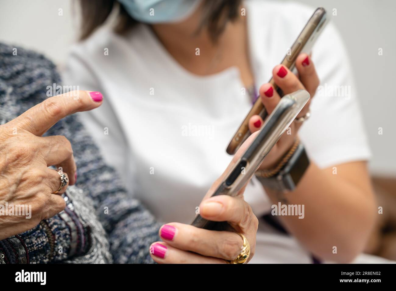 Nurse teaching elder woman how to use mobile phone, senior grandmother ...