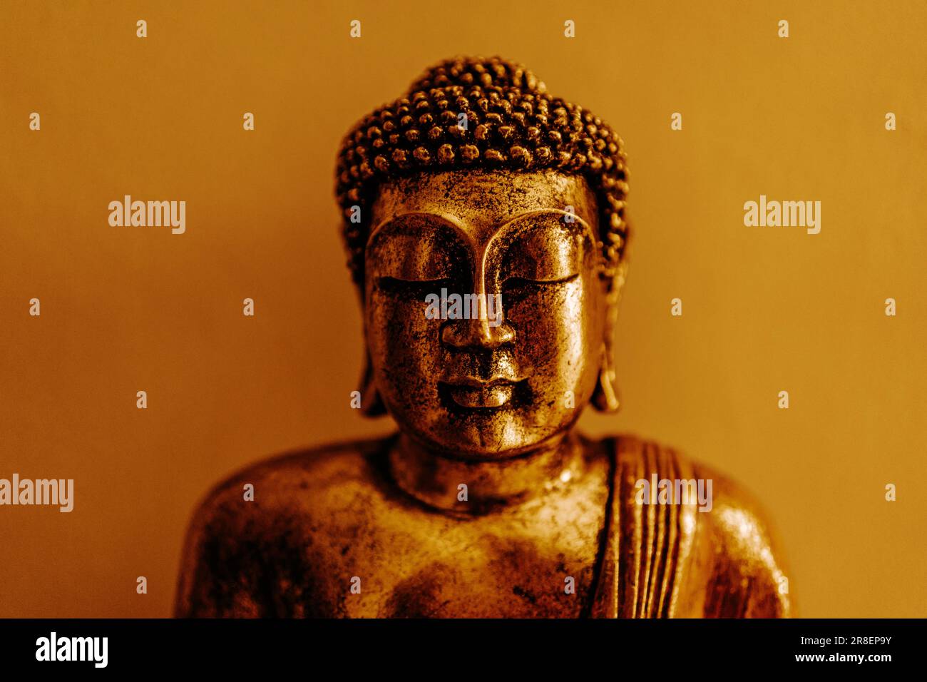 Golden buddha statue portrait in sitting meditation pose on wall ...