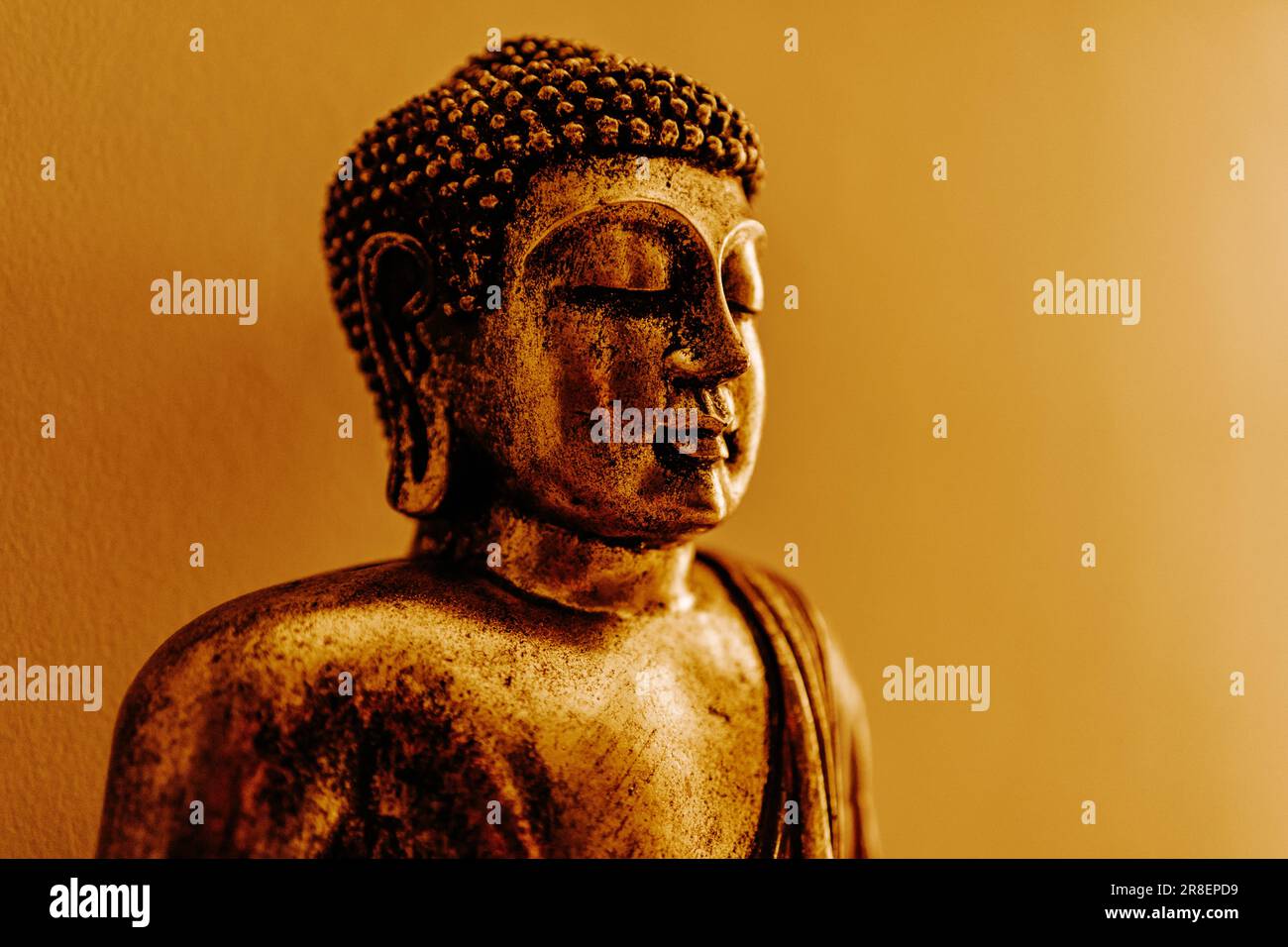 Golden buddha statue portrait in sitting meditation pose on wall ...