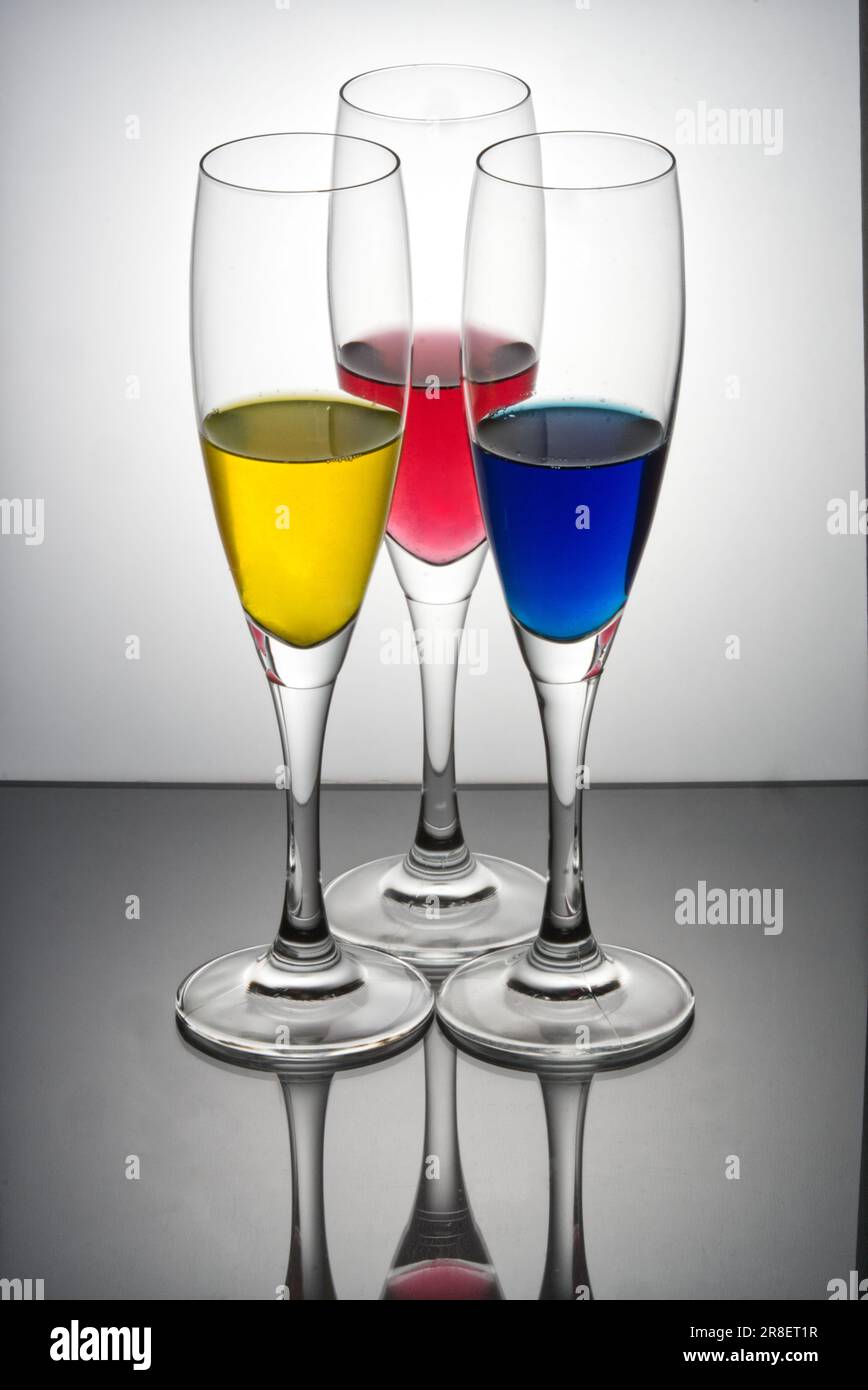 An assortment of brightly colored drinks in clear glasses on a white ...