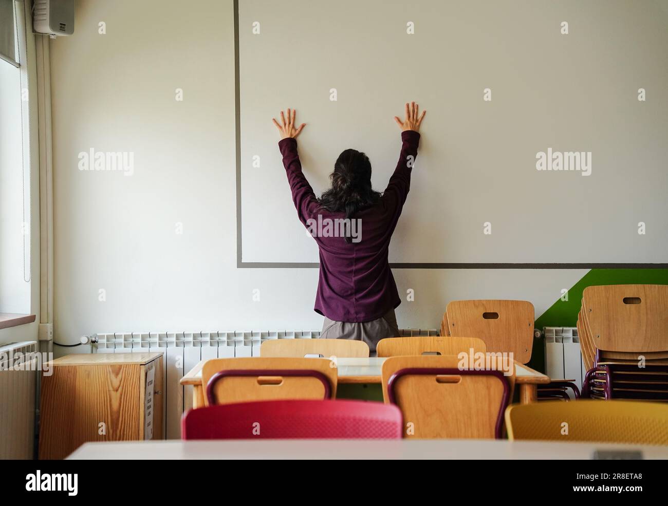 a teacher with her hands on the blackboard in a class at a rural school ...