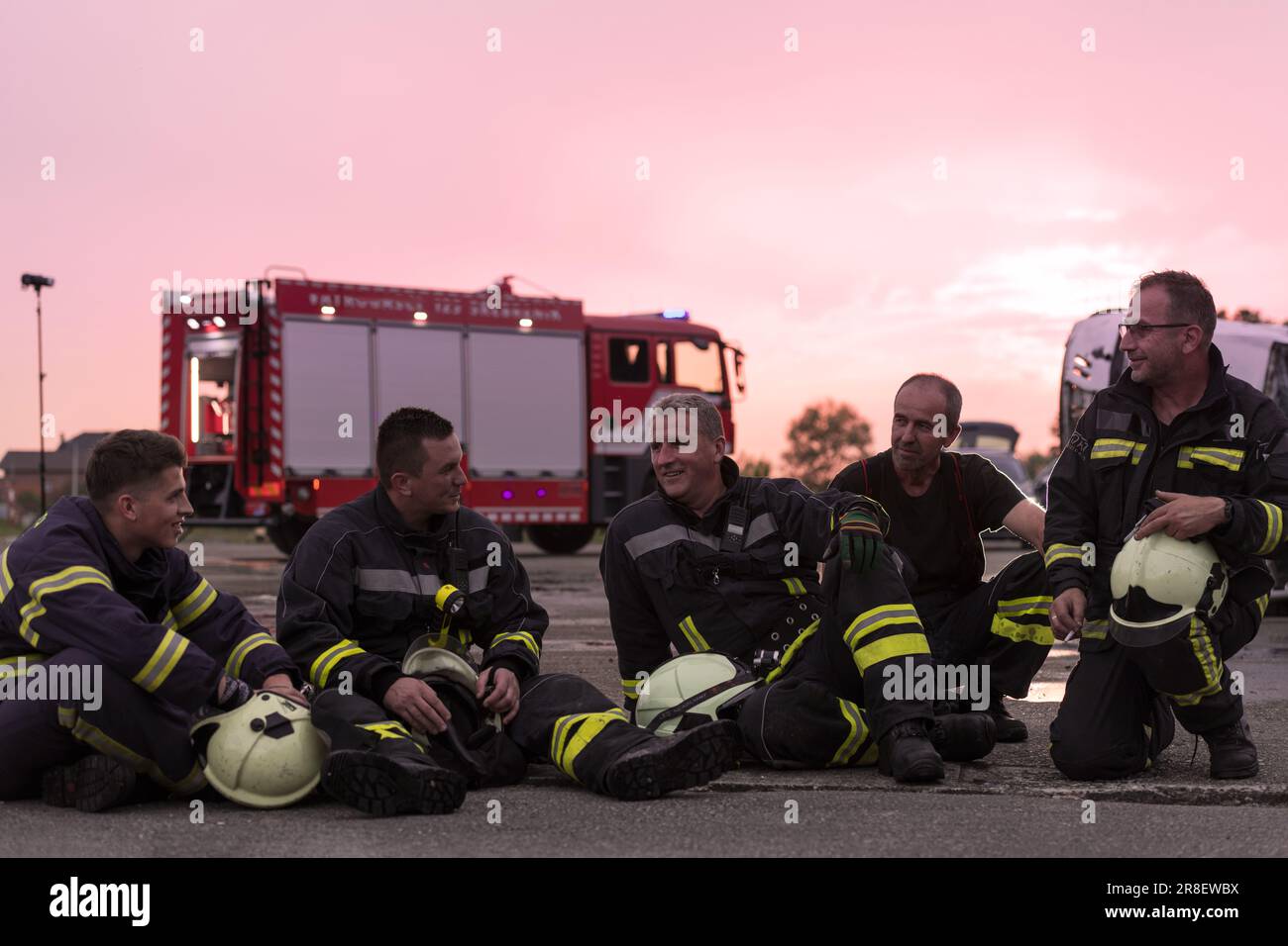 Brave Firefighters Team Walking to the Camera. In Background Paramedics ...