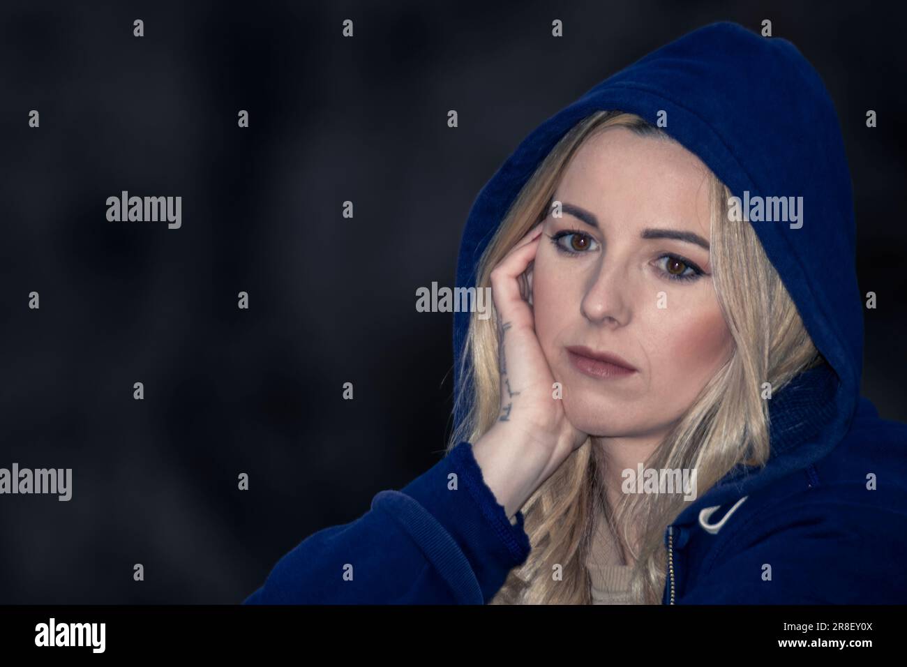 Tragic Reflections: Sad Gaze of a Young Woman in a Blue Hood Stock ...