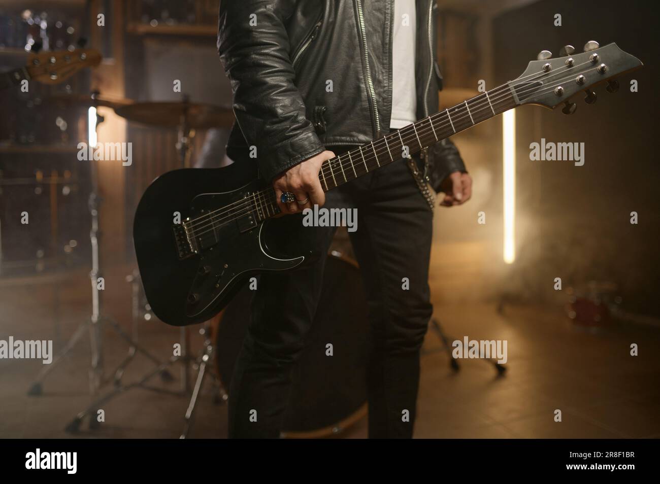 Closeup rock band guitarist holding music instrument over smoky stage ...