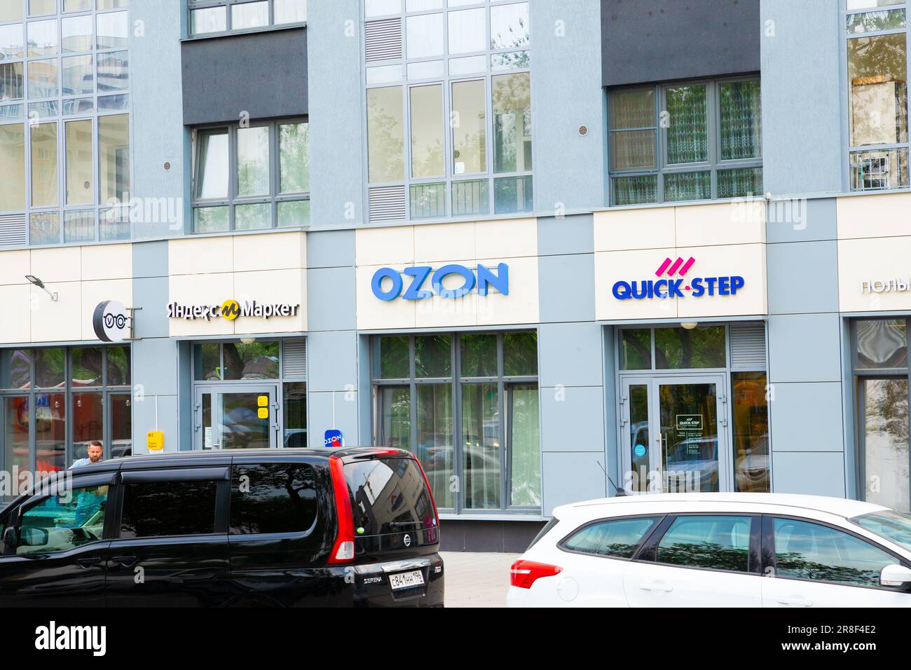Ozone sign, Yandex market sign, Quick step sign on facade of building, parking and cars. Street ...