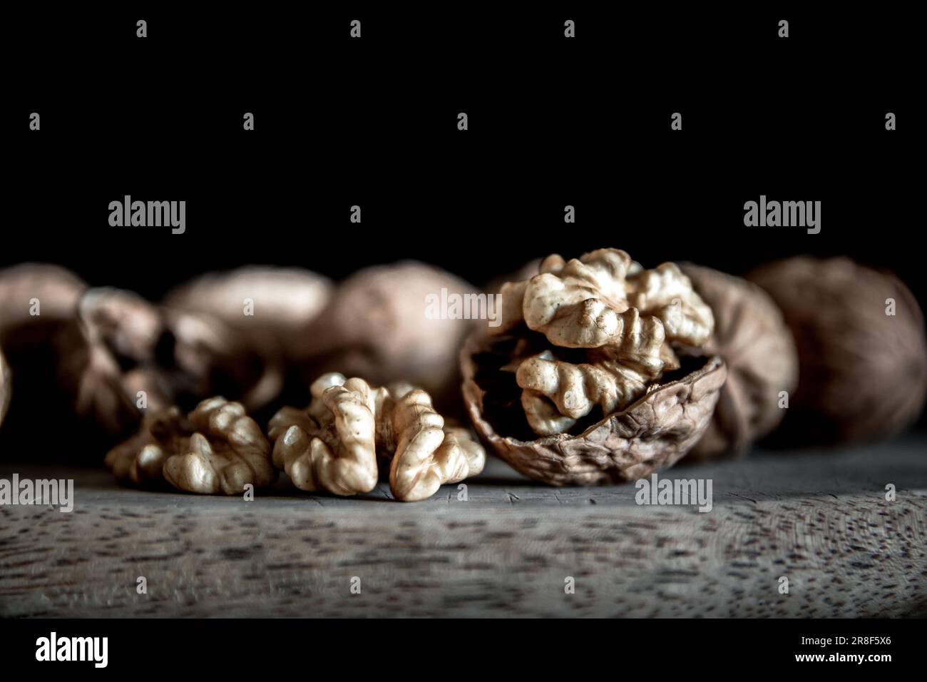 A pile of freshly picked walnuts arranged in a neat row on a rustic ...