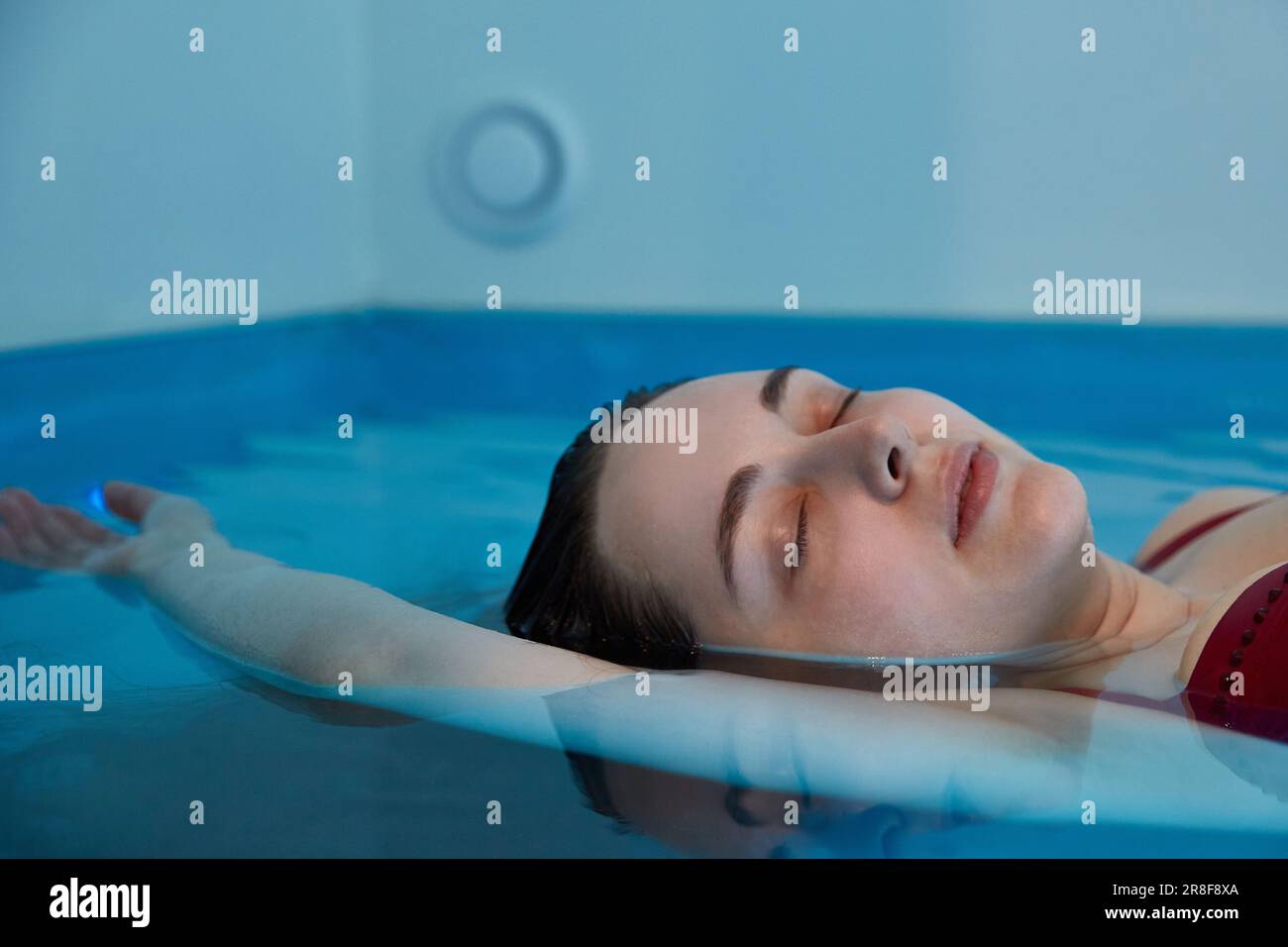 Beautiful woman floating in tank filled with dense salt water used in ...
