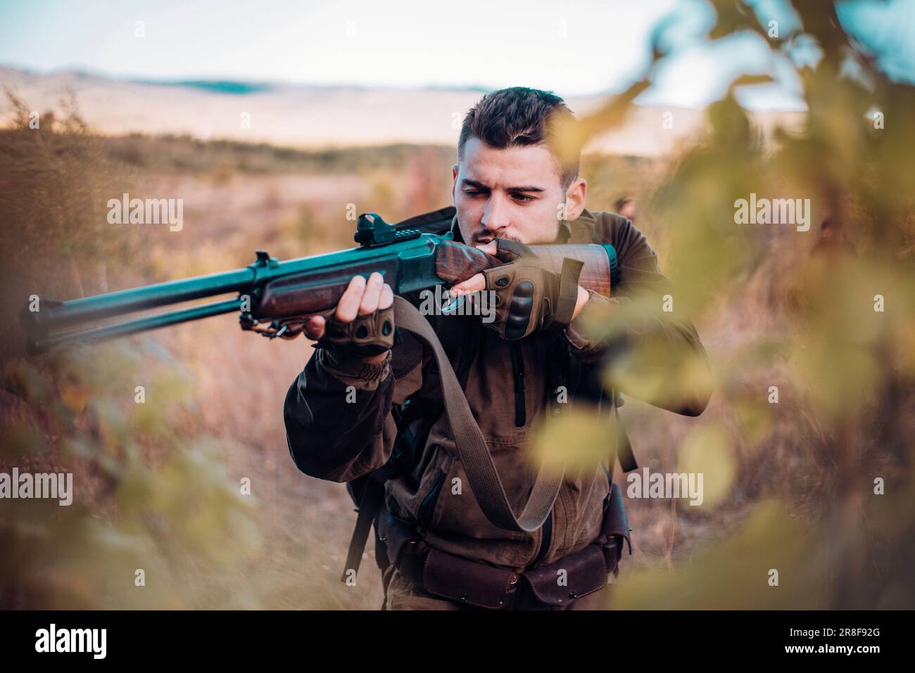 Hunter aiming rifle in forest. Hunter with shotgun gun on hunt. Track ...