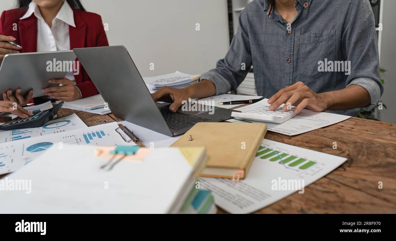 Businesspeople using a calculator to calculate numbers on a company's ...