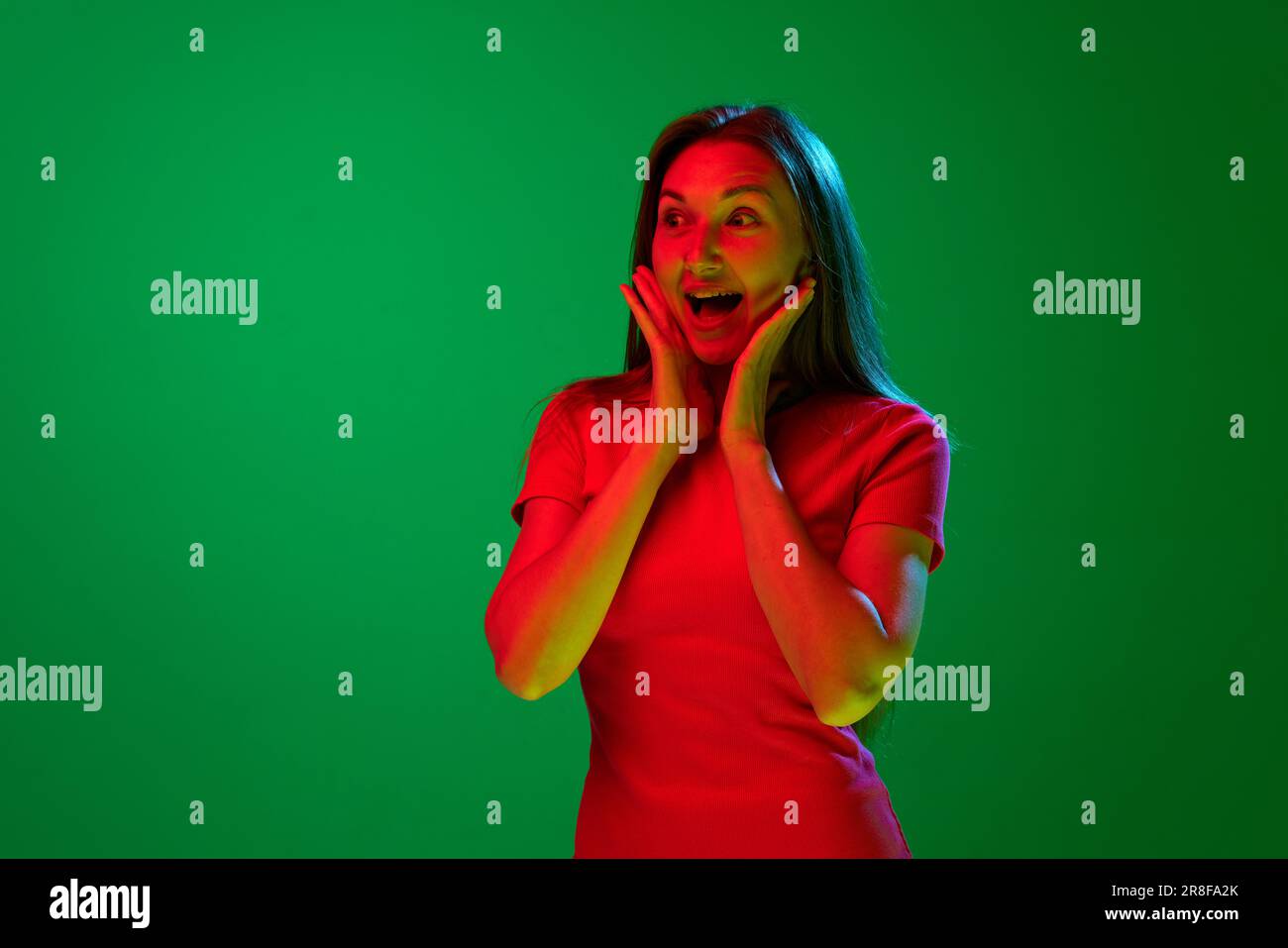 Happy shocked face. Portrait of young beautiful woman in red dress ...