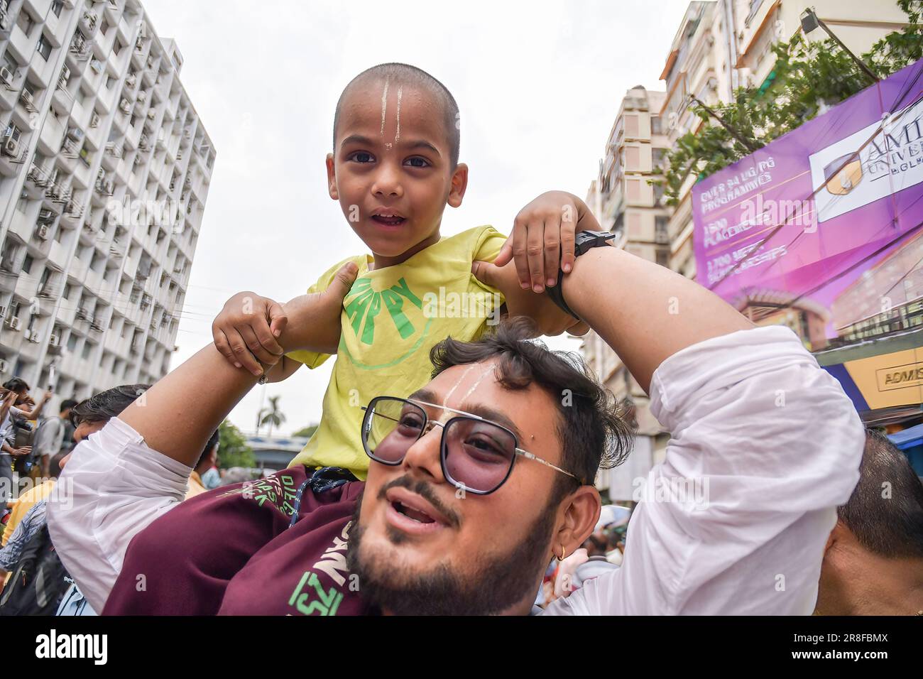 Kolkata, India. 20th June, 2023. A devotee holds a young child on his ...