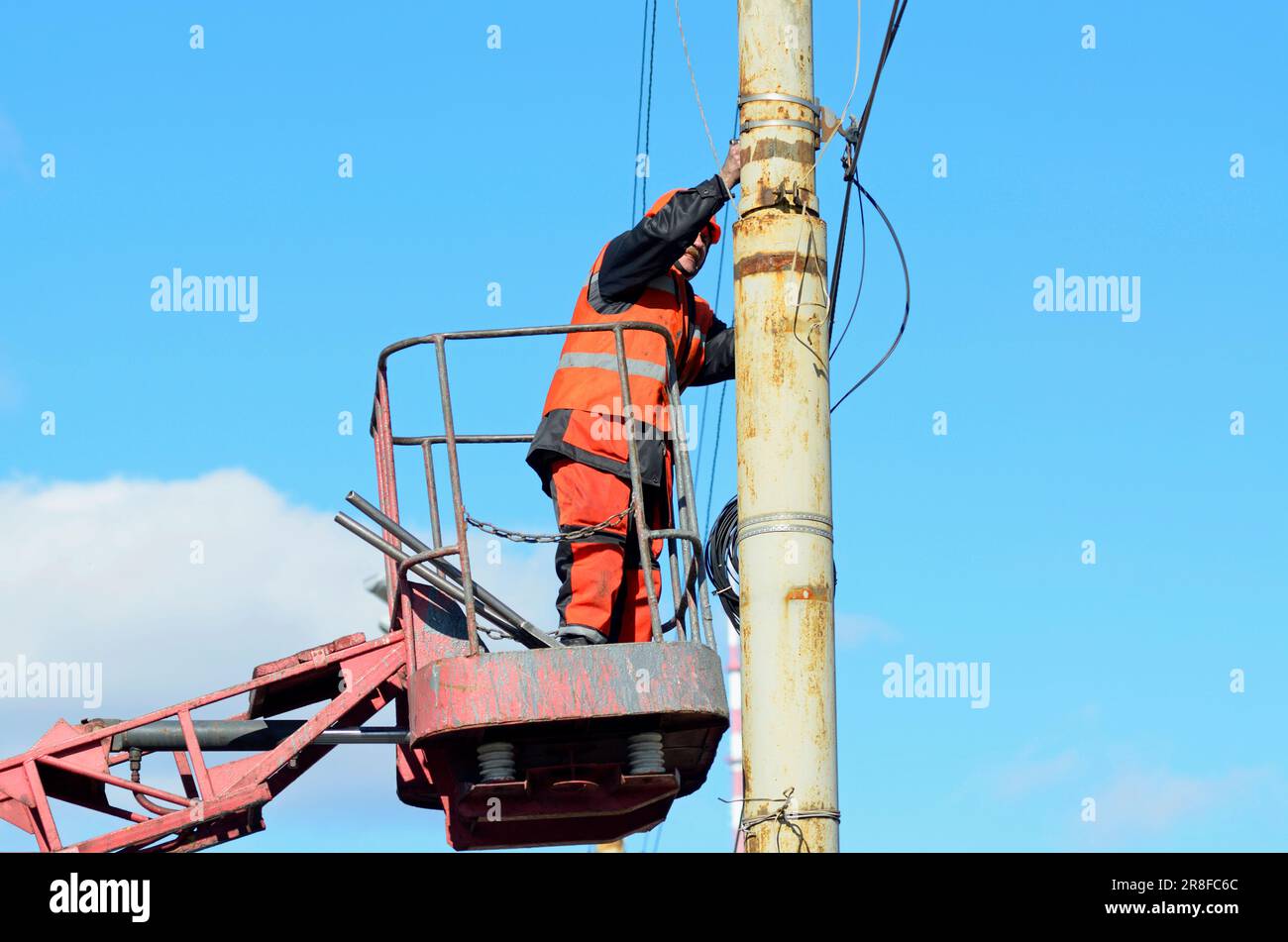 Man ironworker repairing trolleybus rigging standing on a truck mounted ...