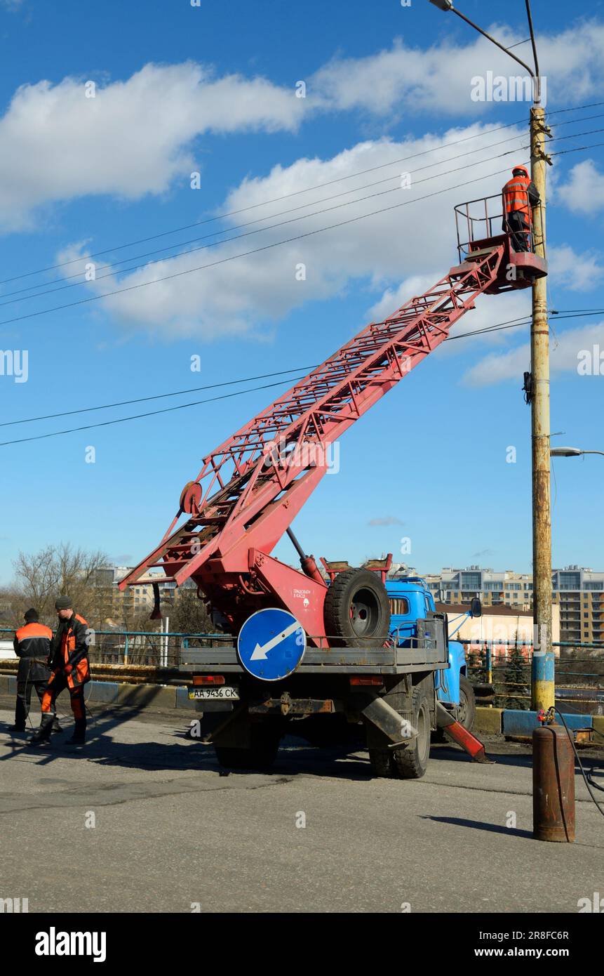 Man ironworker repairing trolleybus rigging standing on a truck mounted ...