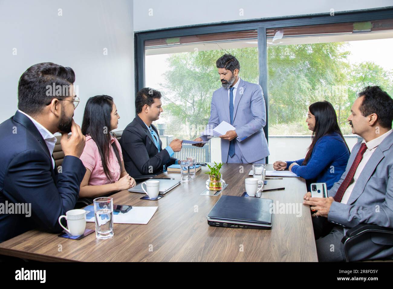 Indian businessman discussing work and plans with employees in ...