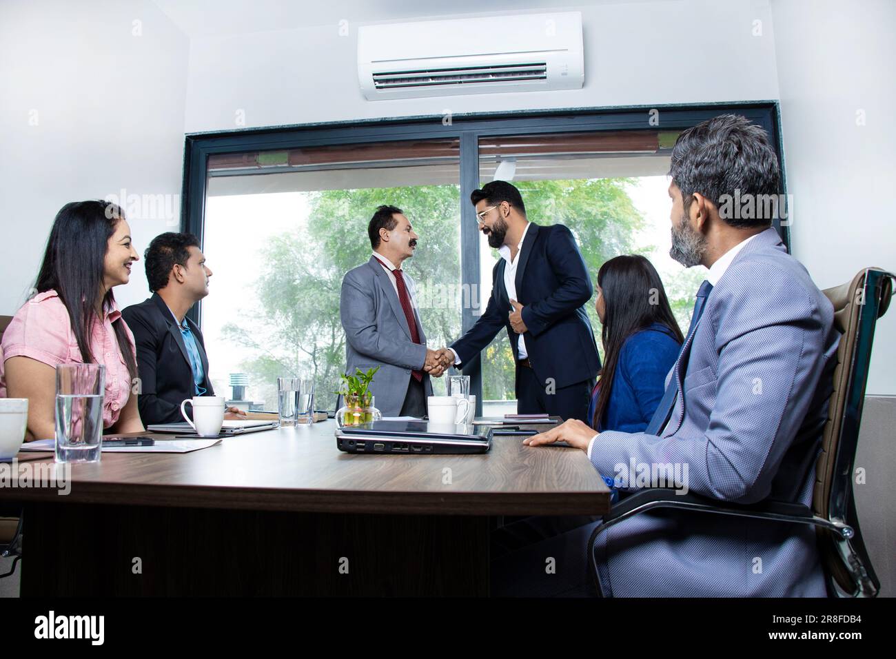 Group of indian business people handshaking after finishing up a ...