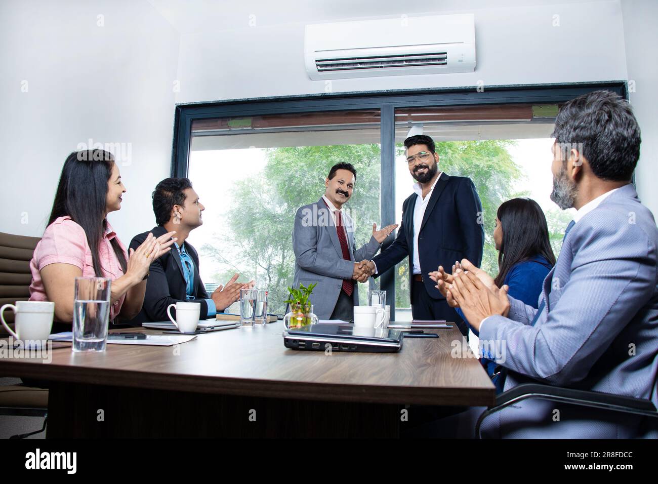 Group of indian business people handshaking after finishing up a ...