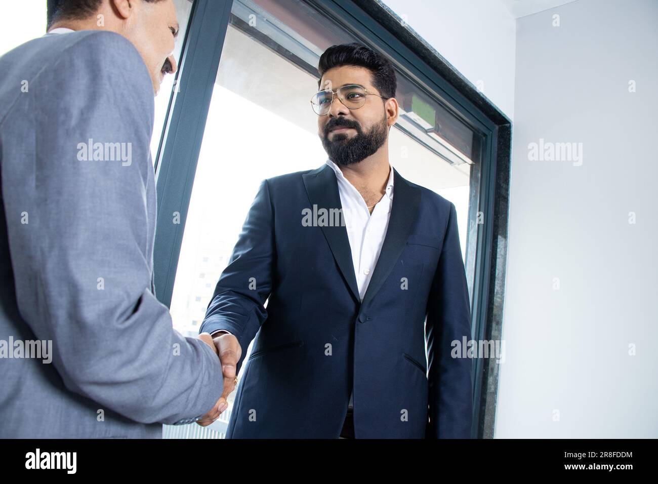 Young Indian business people handshaking after finishing up a meeting ...