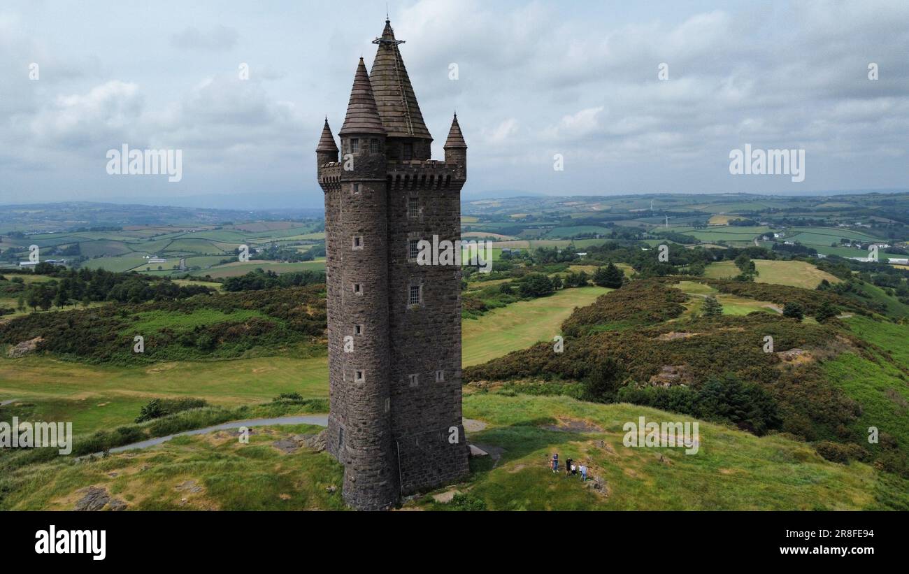 An aerial view of the Scrabo tower situated atop a rolling grassy hill ...