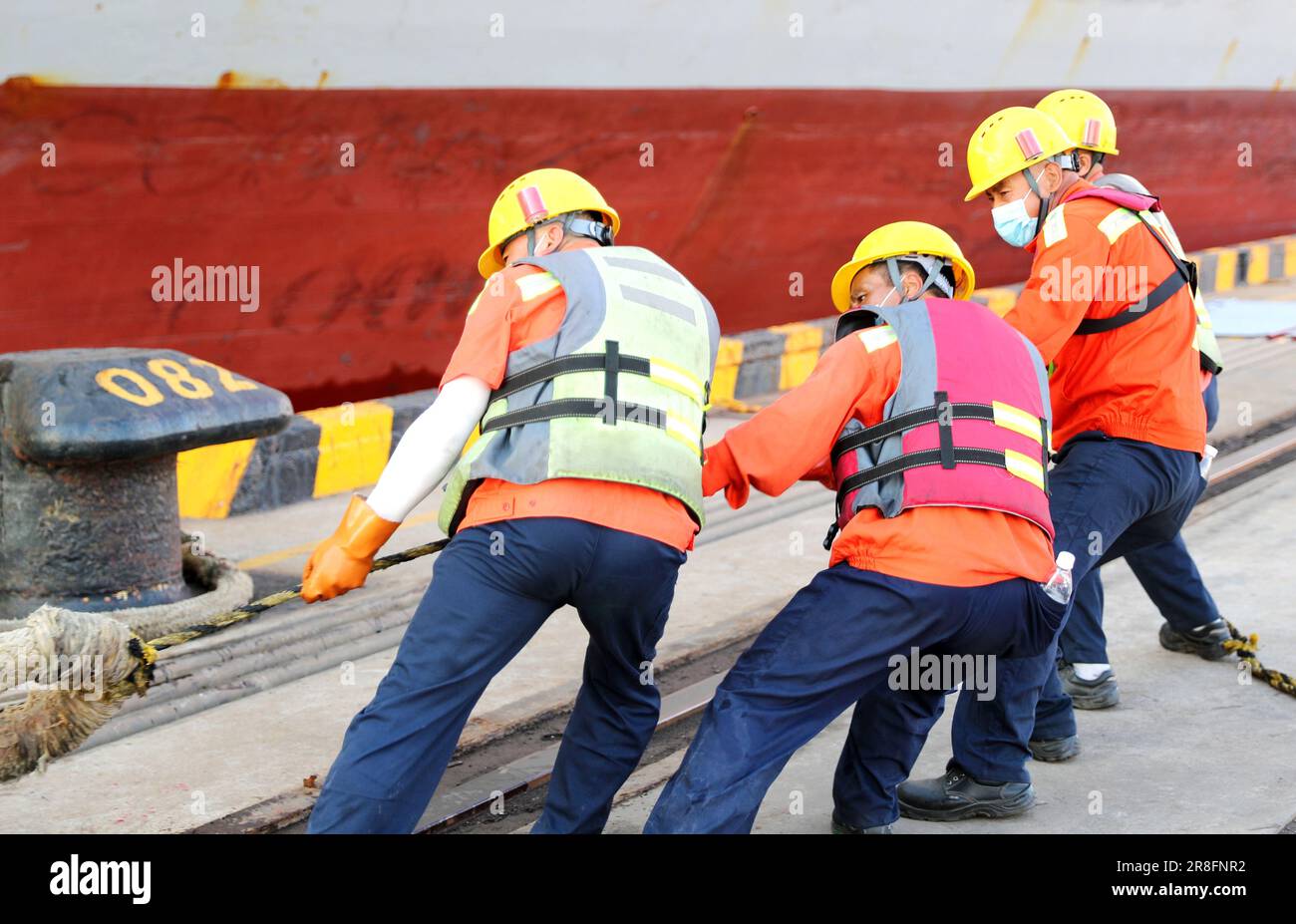 QINGDAO, CHINA - JUNE 21, 2023 - Workers drag a cable at the Qianwan ...