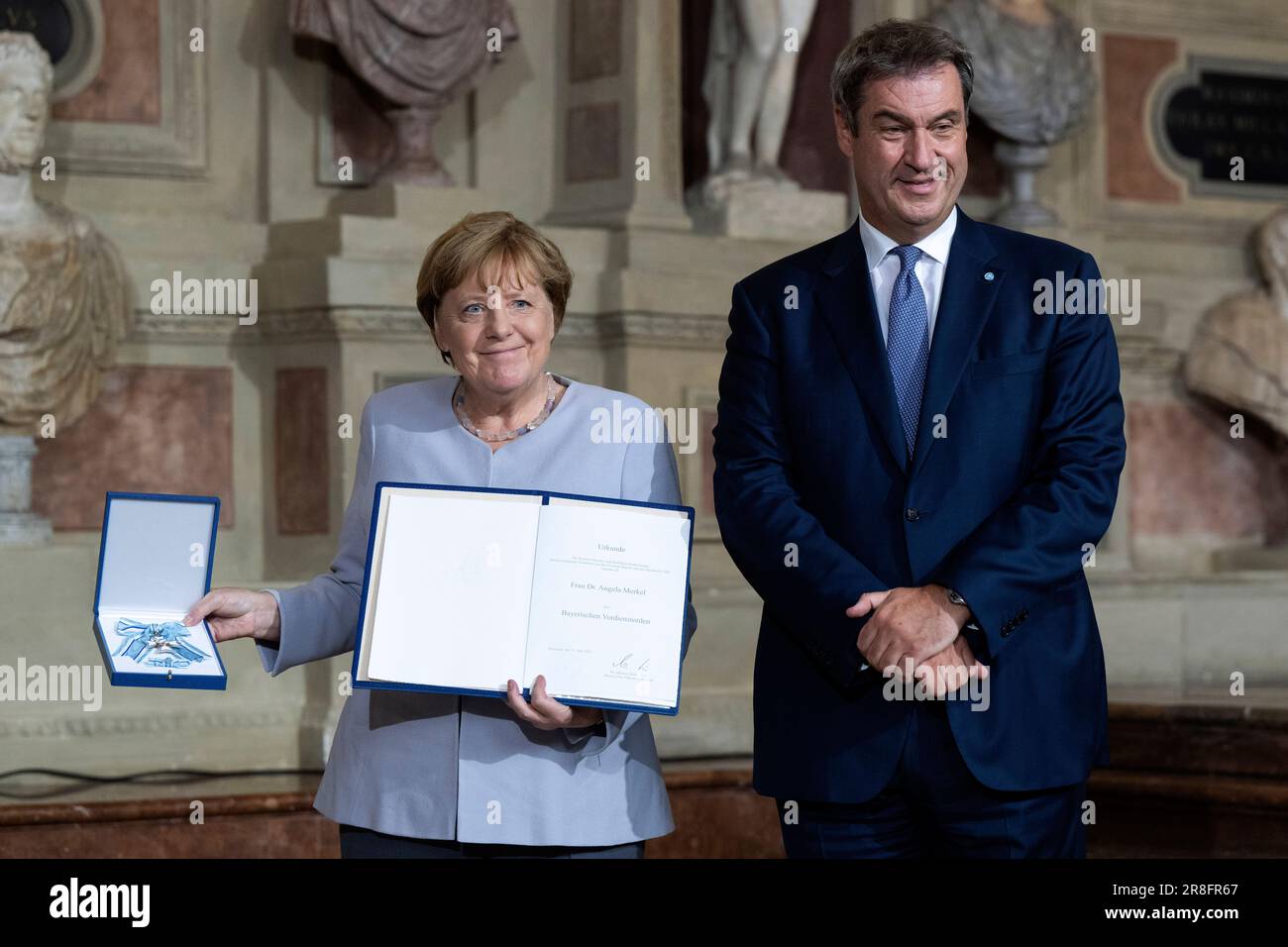 Former German Chancellor Angela Merkel, left, poses with her award of ...