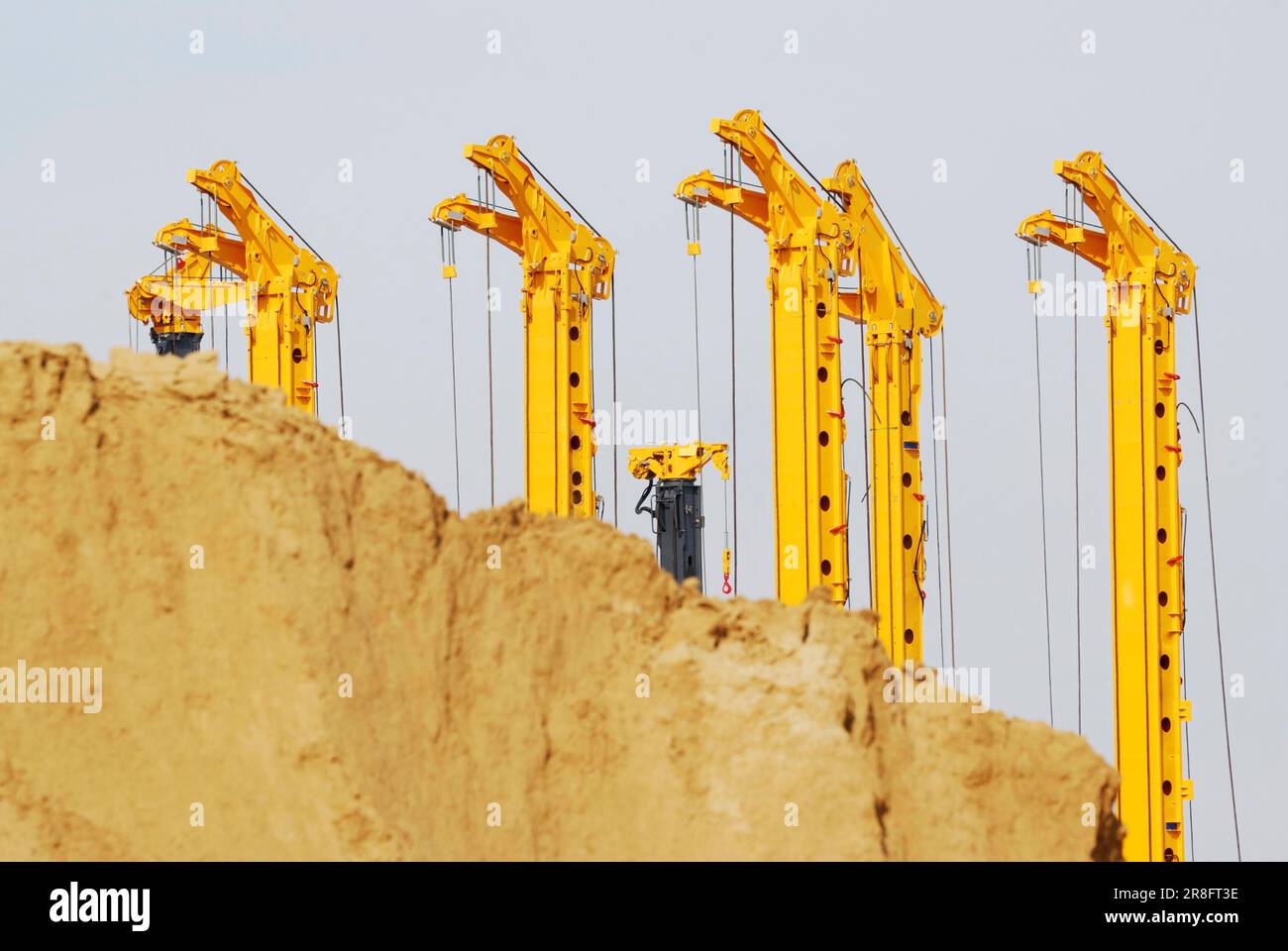 Construction site with drilling rigs behind a sand hill Stock Photo - Alamy