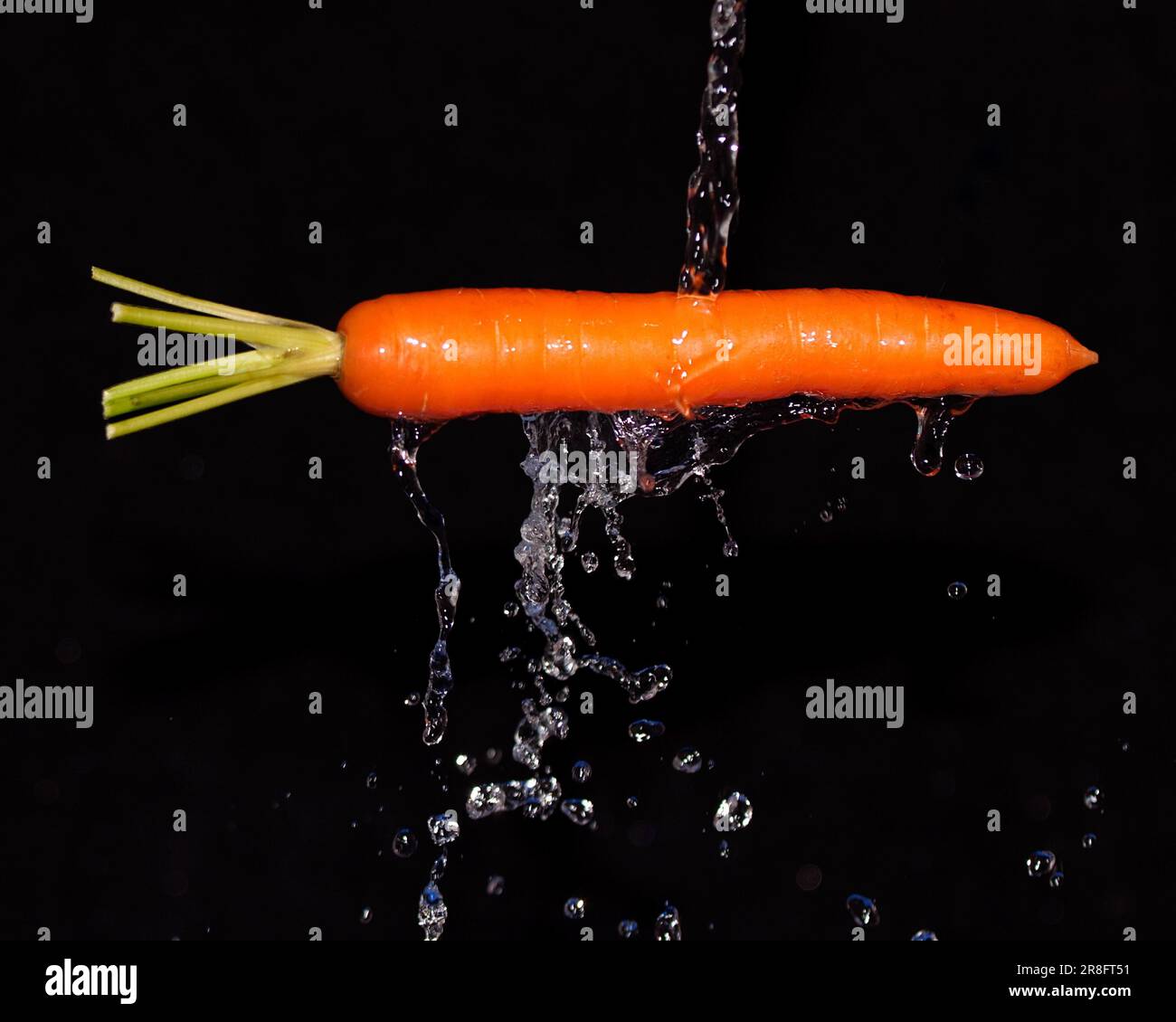 Carrot with water splash beforeBlack Stock Photo - Alamy
