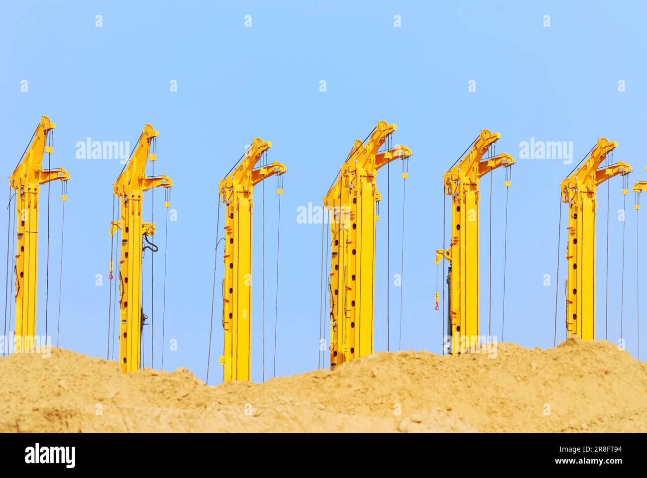 Construction site with drilling rigs behind a sand hill Stock Photo - Alamy