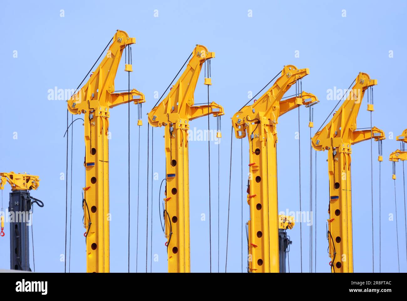 Row of yellow drilling rigs Stock Photo - Alamy