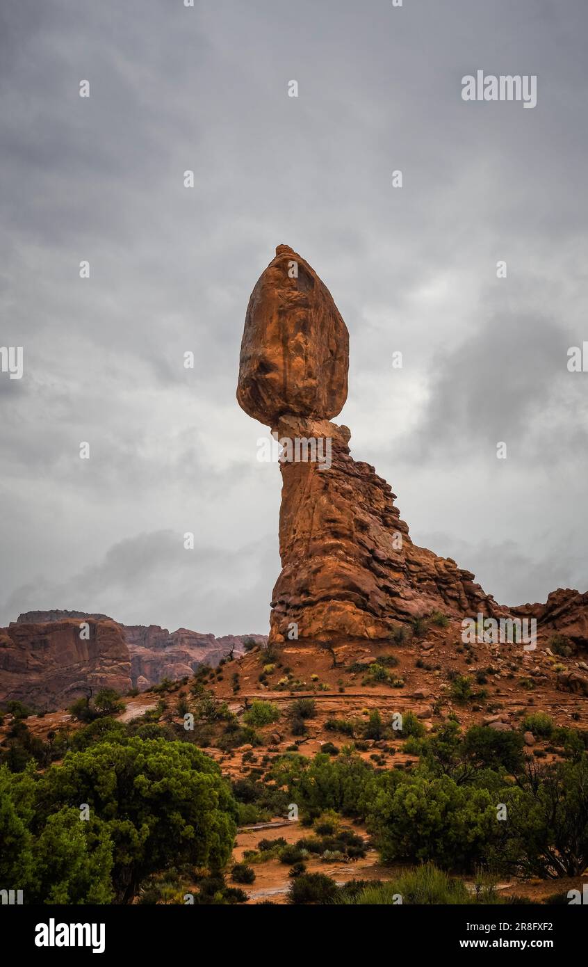The unique rock formation in the vast desert landscape, surrounded by ...