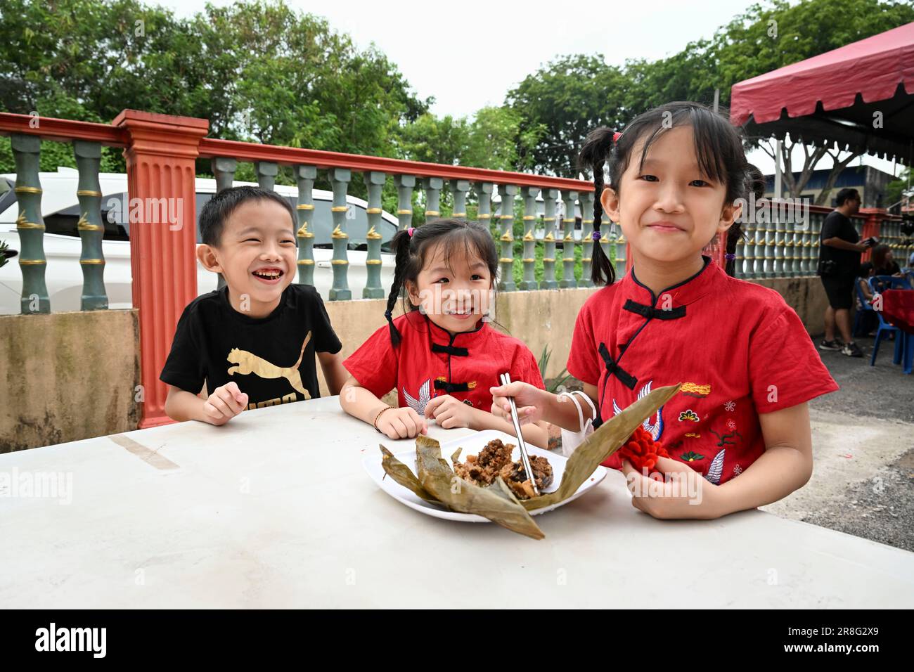 Malacca, Malaysia. 18th June, 2023. Children taste Zongzi, a pyramid ...