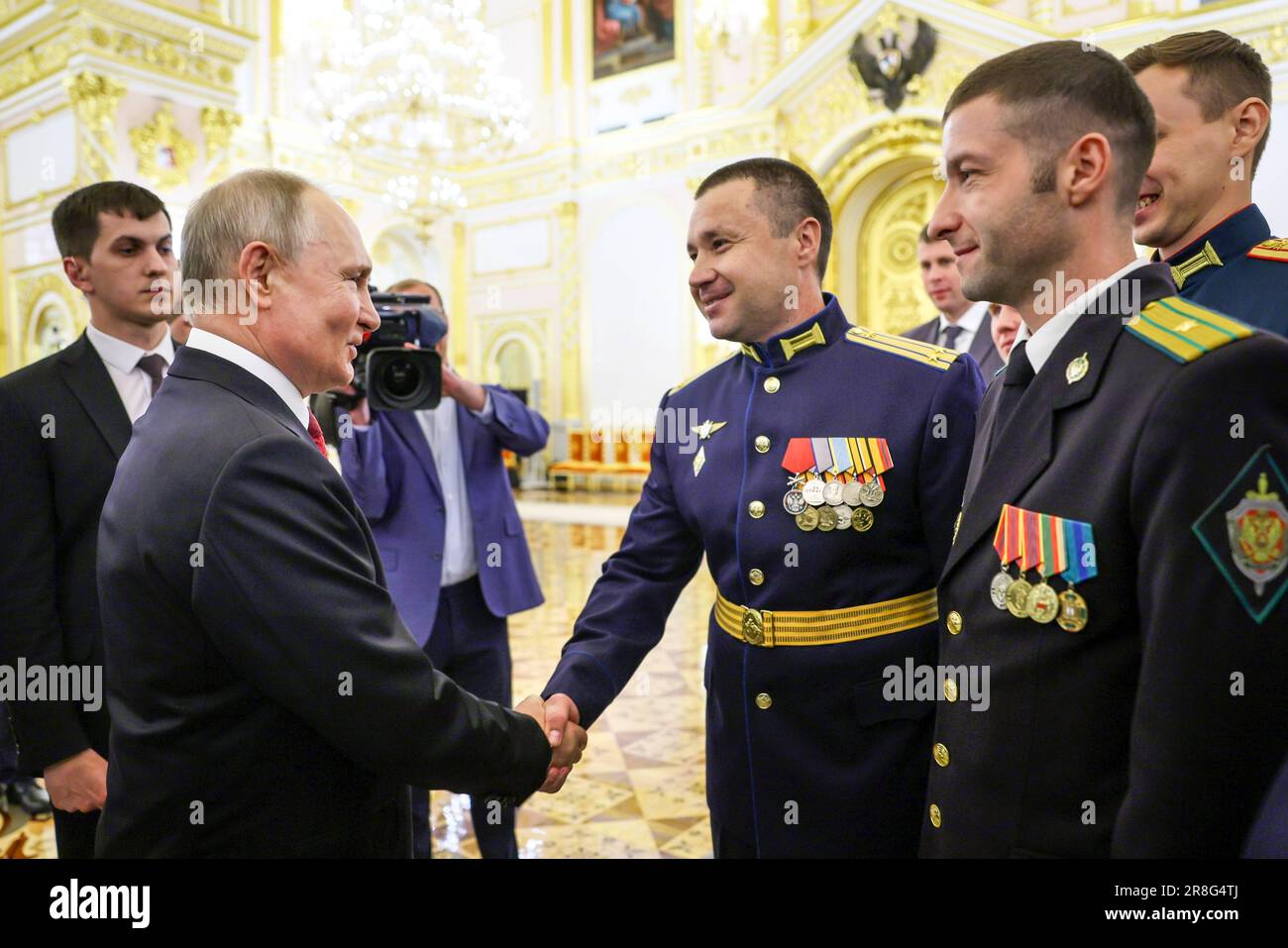 Russian President Vladimir Putin, left, greets graduates of military ...