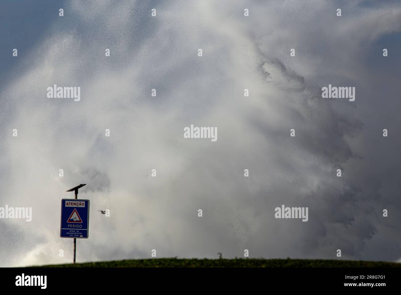 Northern portuguese coast during sea storm. Danger warning sign says ...