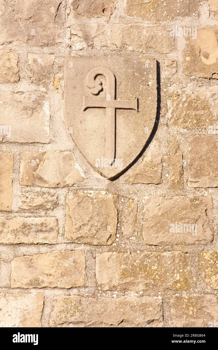 The relief of a cross with a walking stick in a medieval archway ...