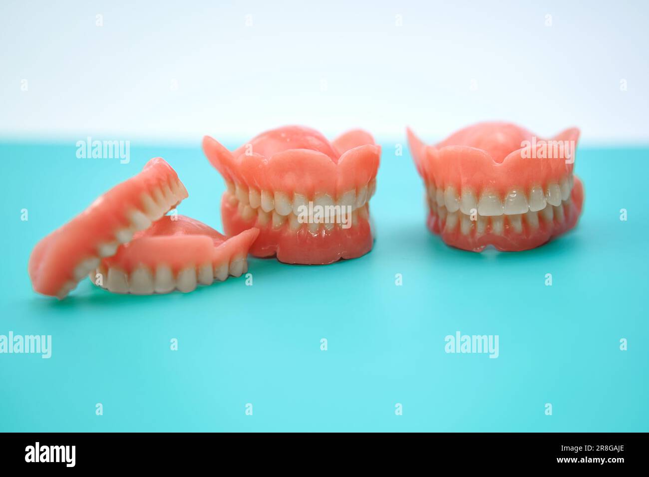 Close-up of a group of dentures on top of a green work table in a ...