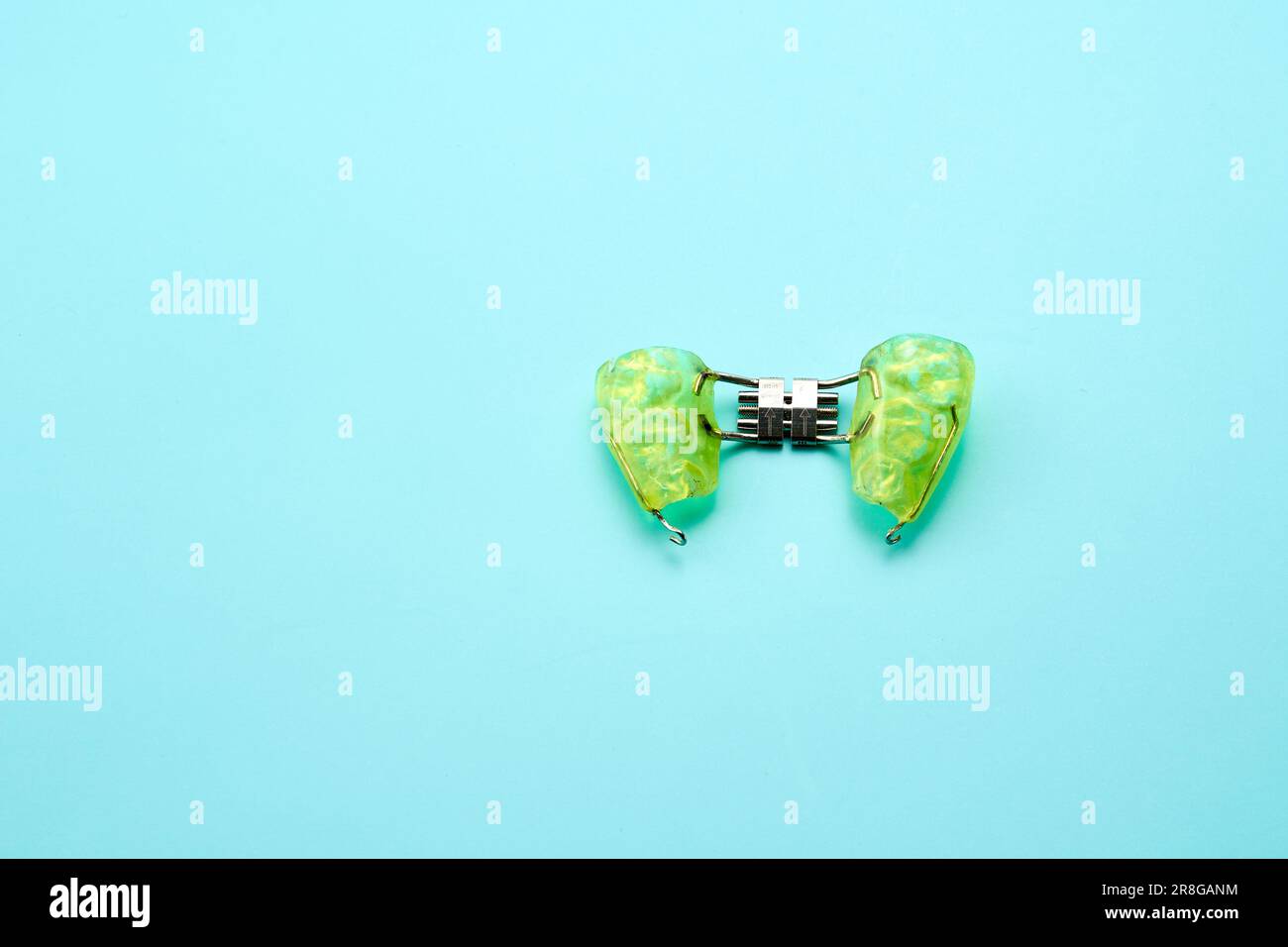 Green orthodontic appliance to open the patient's palate, on a greenish ...