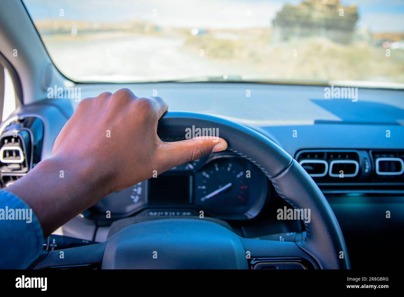A person's hand gripping the steering wheel while in the car Stock ...