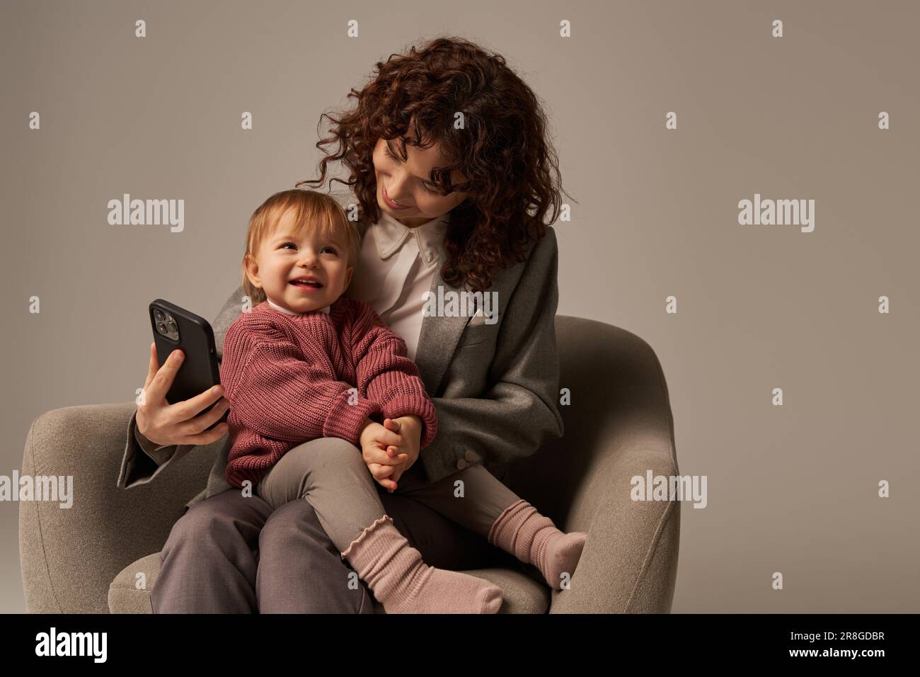 modern working mother, multitasking, using smartphone, balancing work ...