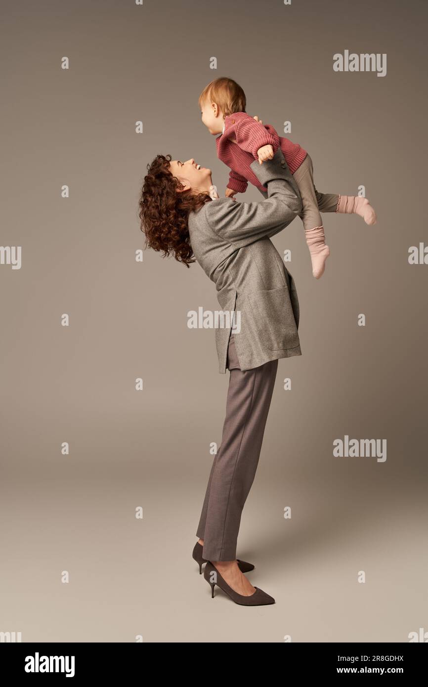 quality time, parenting and career, cheerful businesswoman lifting her ...
