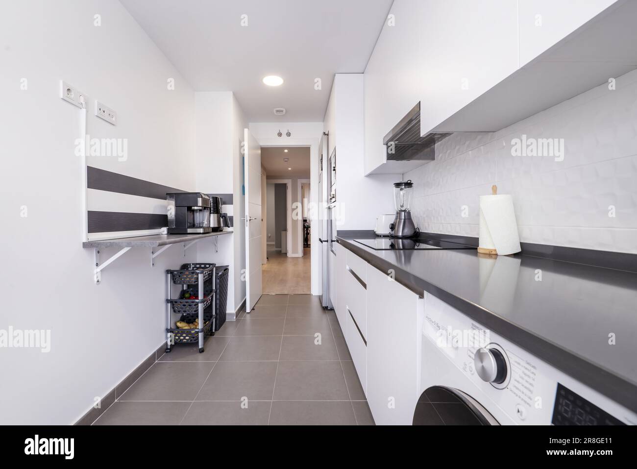 elongated kitchen with furniture to one side with gray countertop and ...