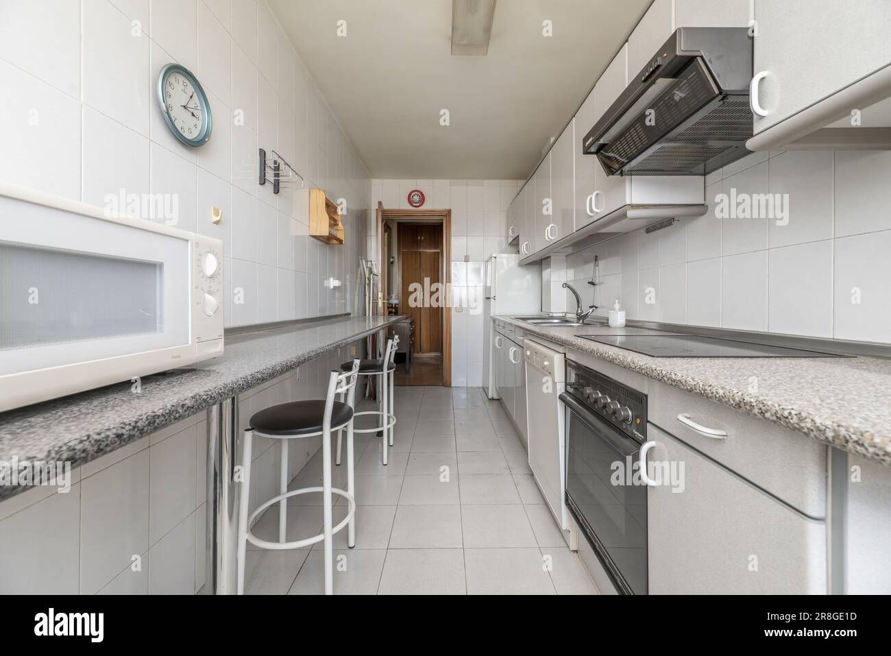 elongated kitchen with cabinets on one side with similar granite ...